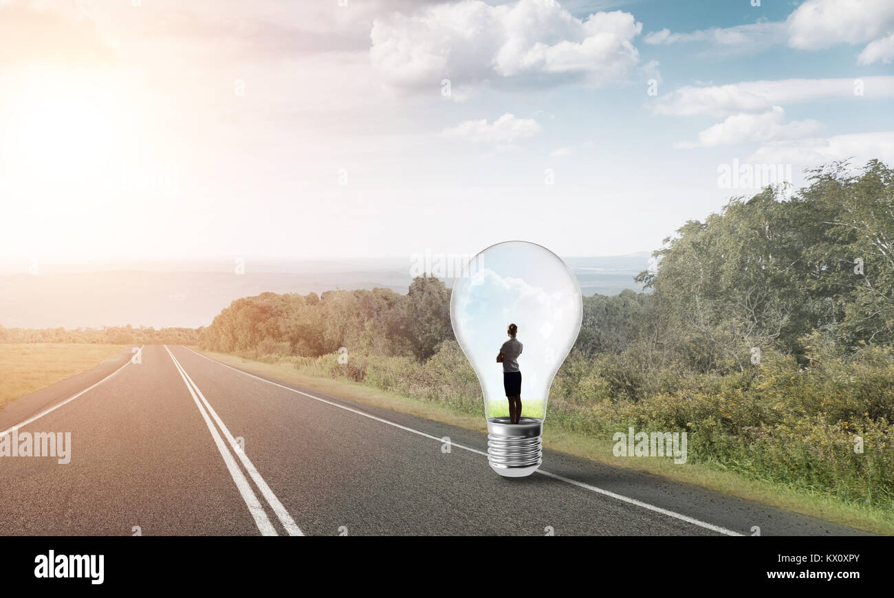 Young businesswoman trapped inside of light bulb on asphalt road Stock ...