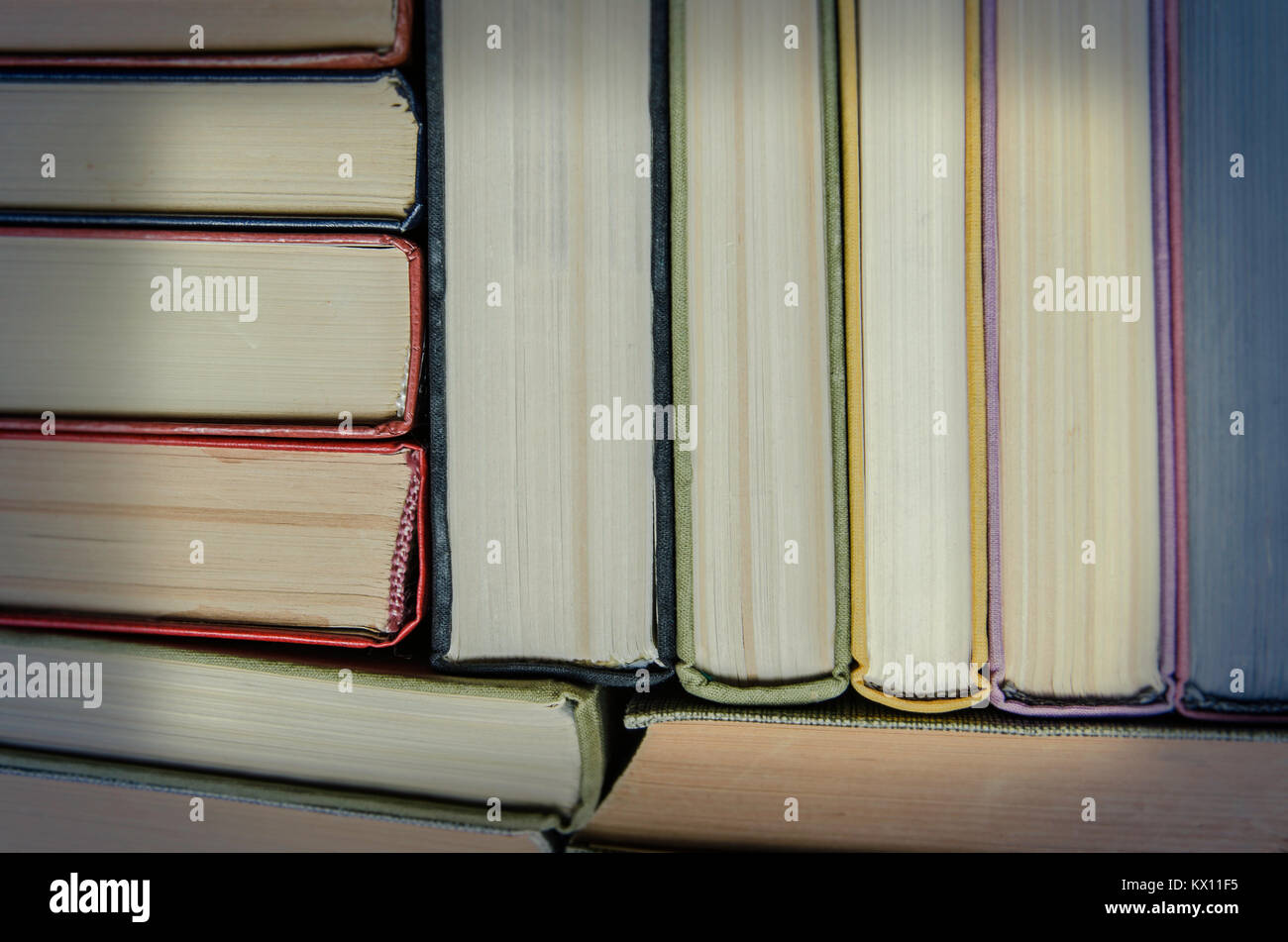 a stack of colorful books in a library like background Stock Photo - Alamy