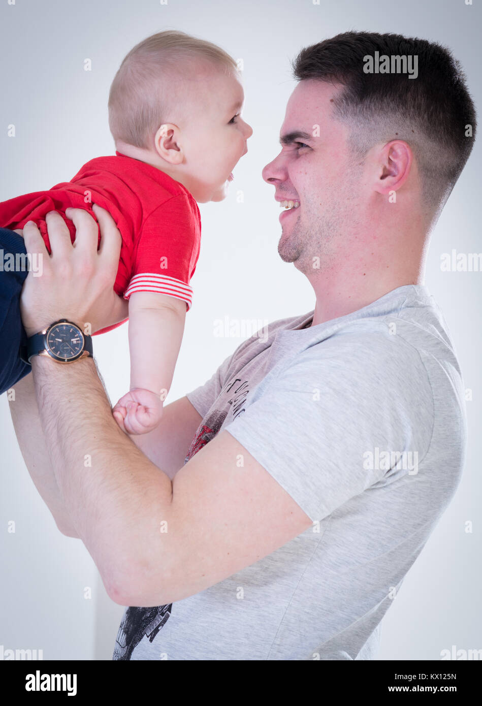 Young happy father with baby boy shooting in the photo studio, smiling ...