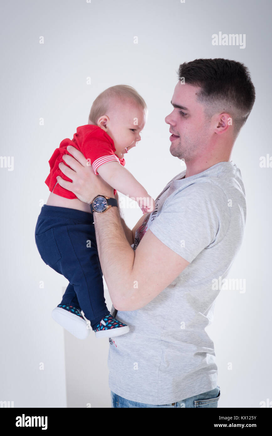 Young happy father with baby boy shooting in the photo studio, smiling ...