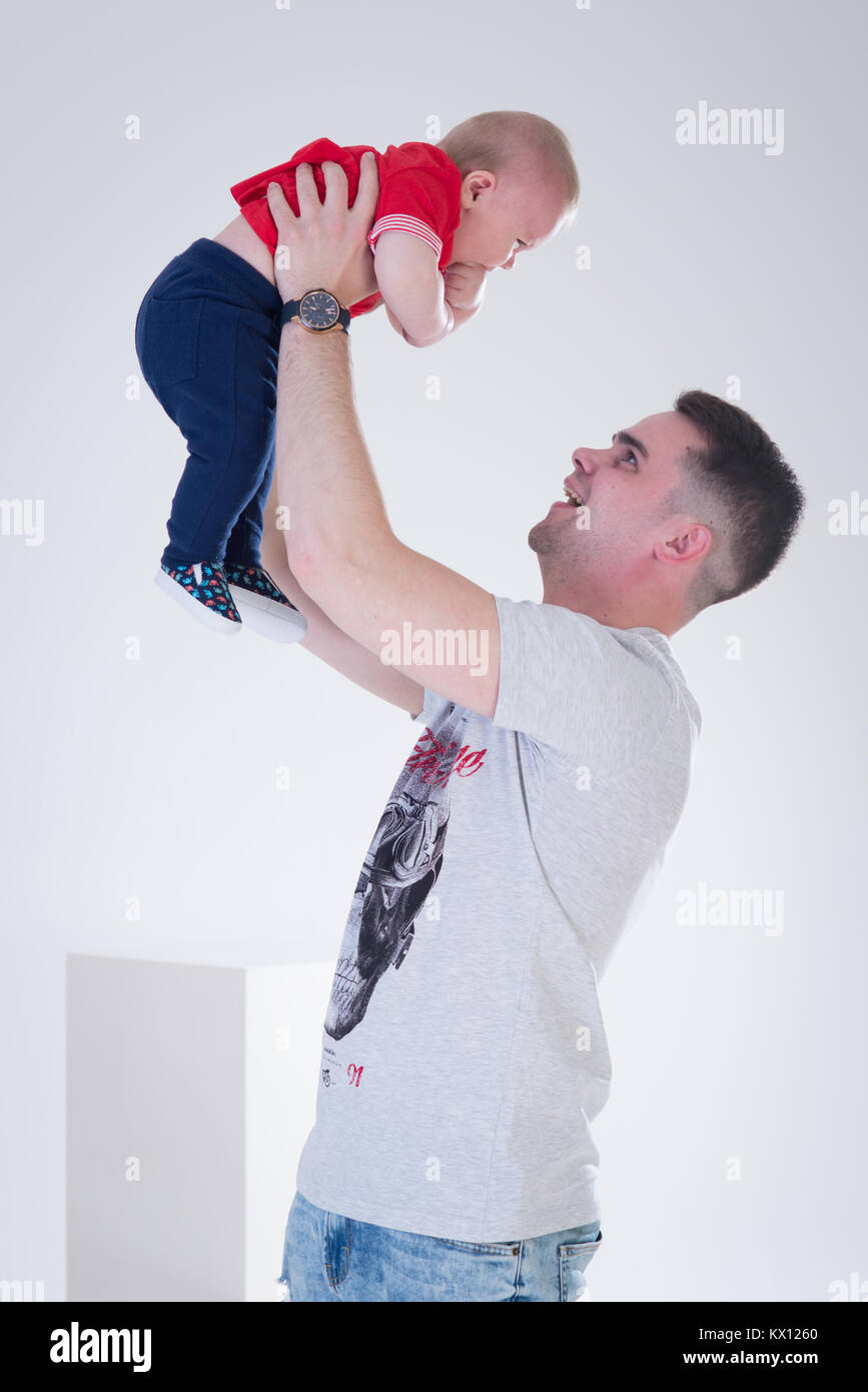 Young happy father with baby boy shooting in the photo studio, smiling ...
