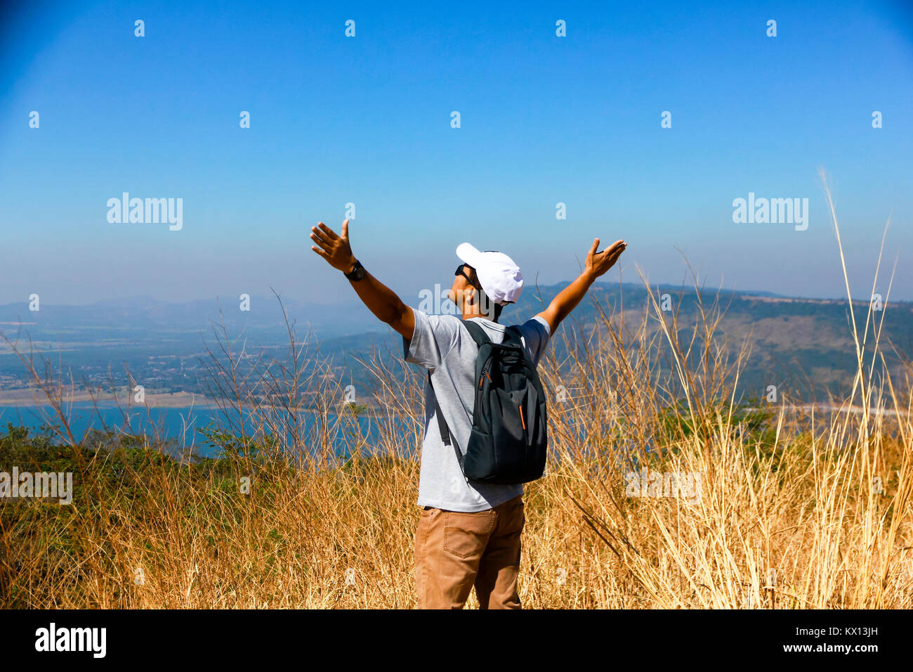 Adventurous man is standing on top of the mountain and enjoying the ...