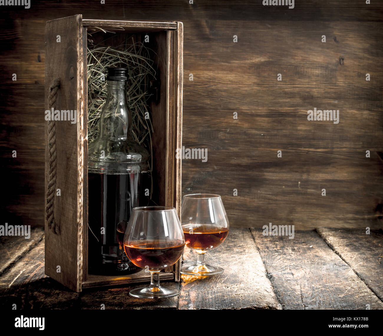 bottle of cognac in an old box. On a wooden background Stock Photo - Alamy