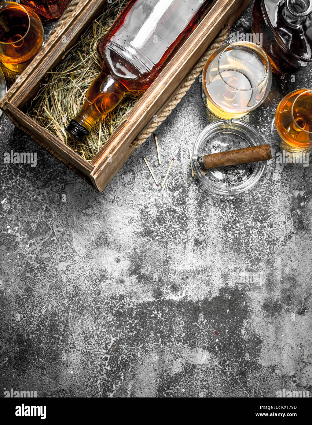 Cognac background. A bottle of cognac with lemon wedges and a cigar. On ...