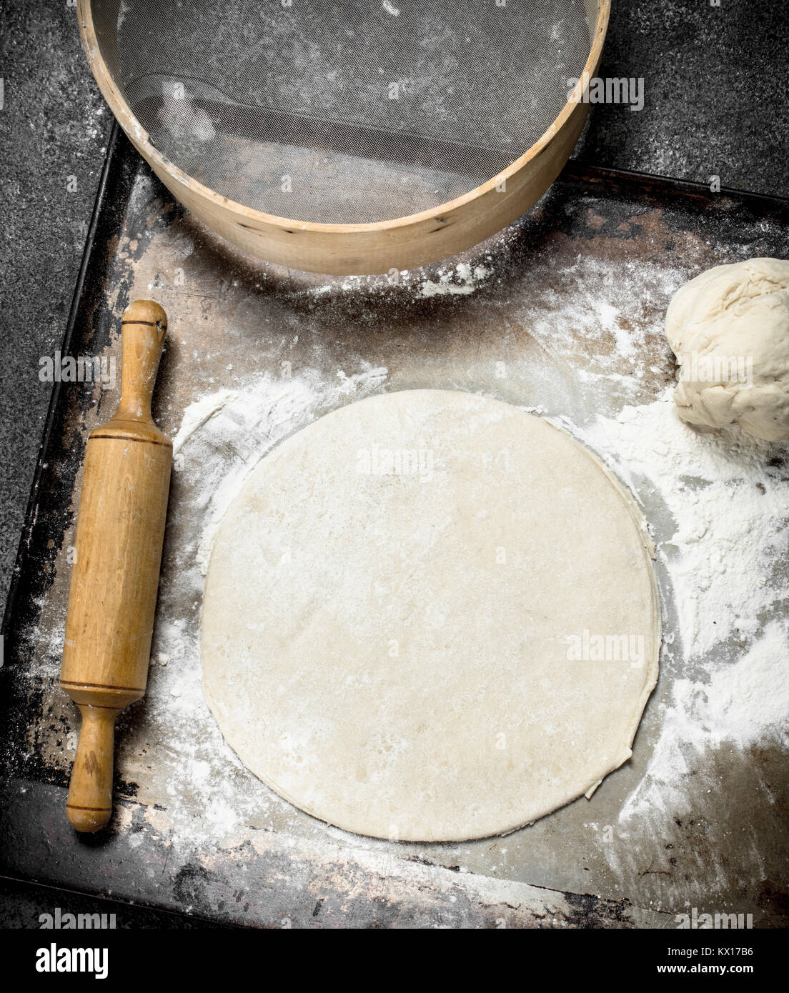 Roll out dough for pizza. On a rustic background Stock Photo - Alamy