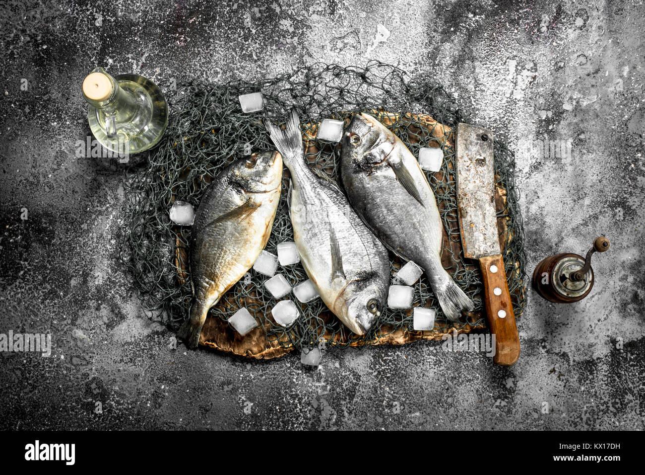 Fresh unprepared dorado fish on a cutting board. On a rustic background ...
