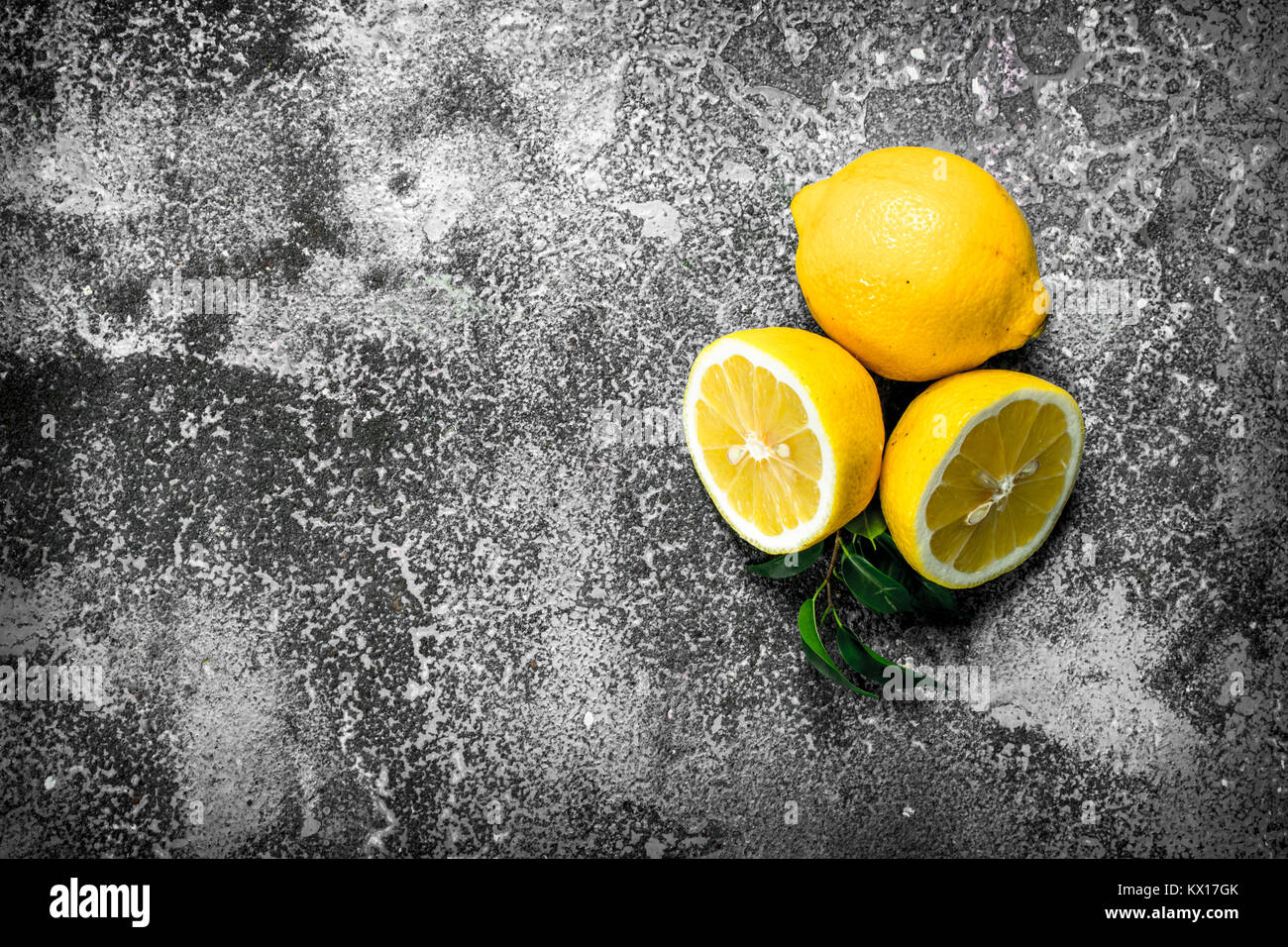Fresh lemons with leaves. On a rustic background Stock Photo - Alamy