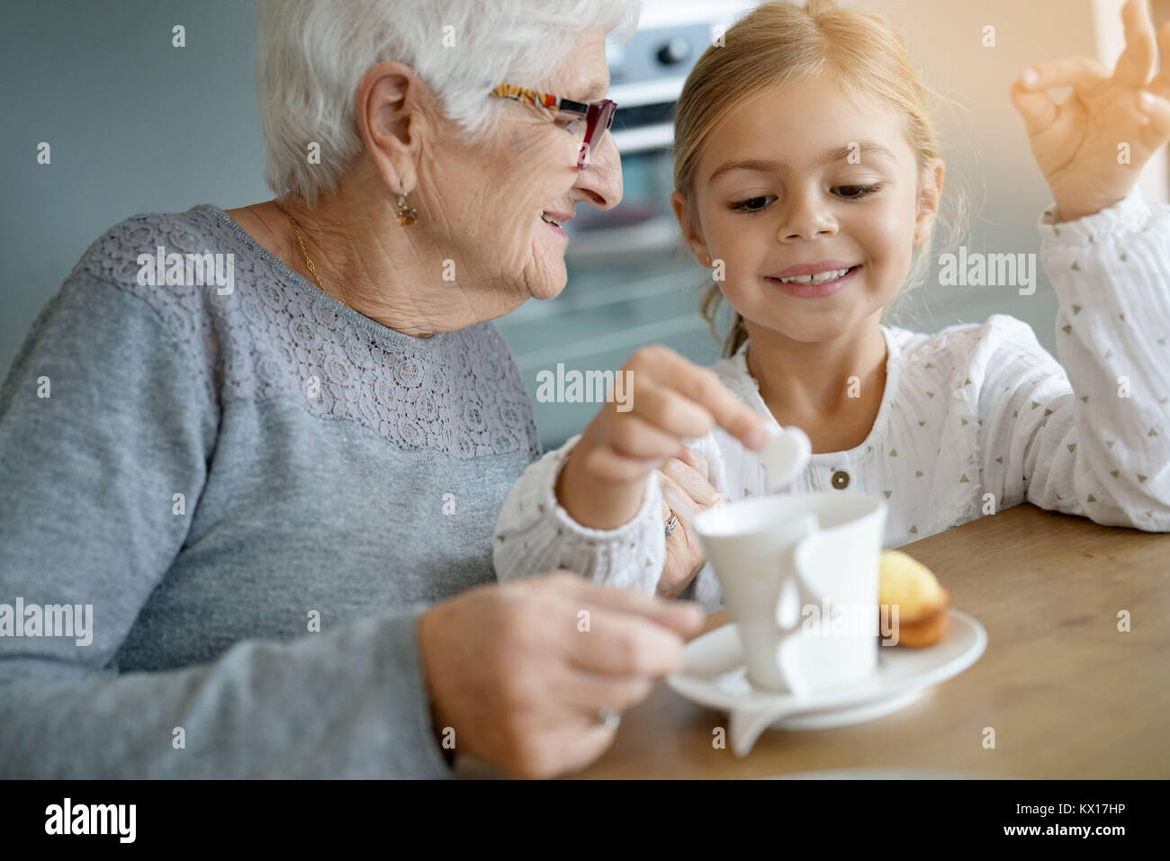 Little girl having tea time with grandma Stock Photo - Alamy