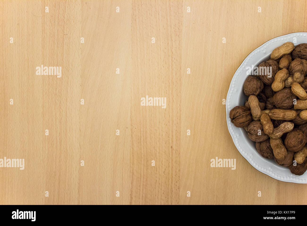 plate of nuts on wooden table, top view with empty space Stock Photo ...
