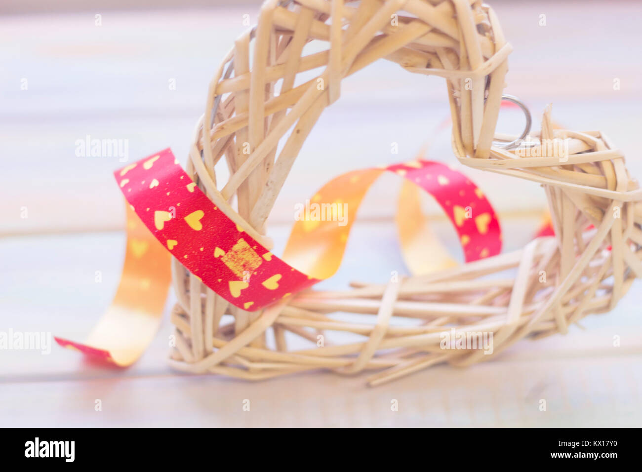 A rattan wreath in a shape of heart with a ribbon Stock Photo - Alamy