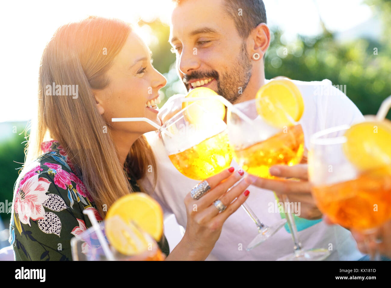 Cheerful couple having fun cheering with cocktails Stock Photo - Alamy