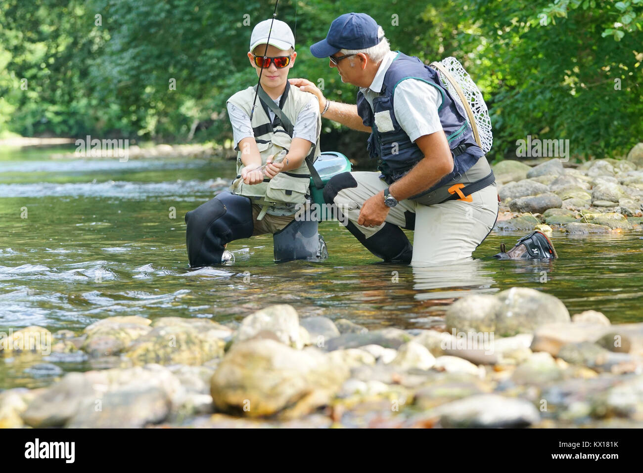 Father and son catching rainbow trout in river Stock Photo - Alamy