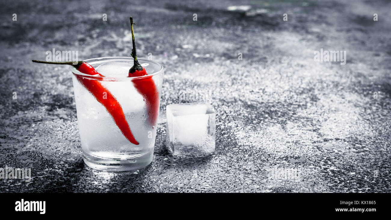 Vodka shots with hot peppers. On a rustic background Stock Photo - Alamy
