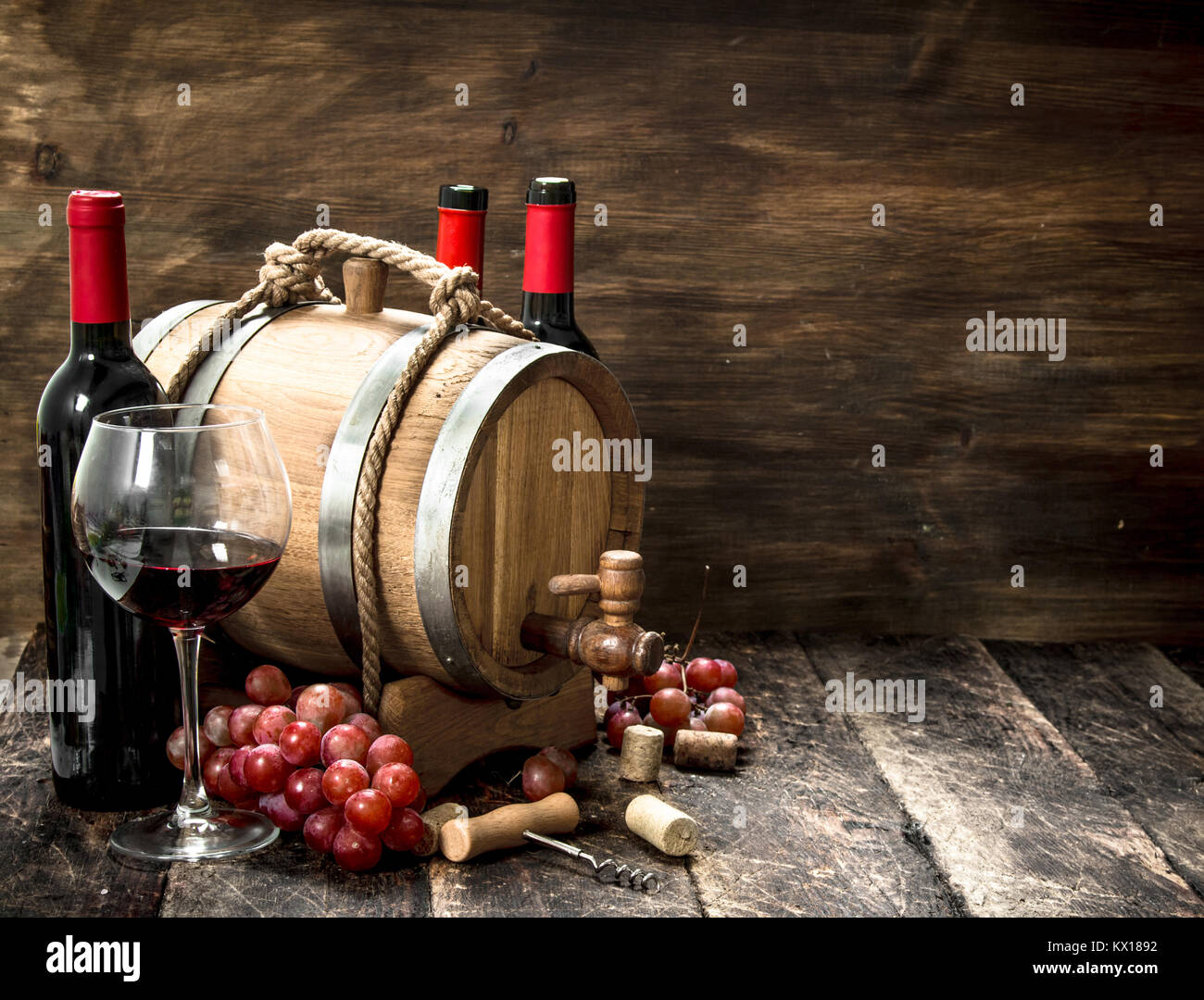 Wine background. A barrel with red wine and freshly grapes. On a wooden ...