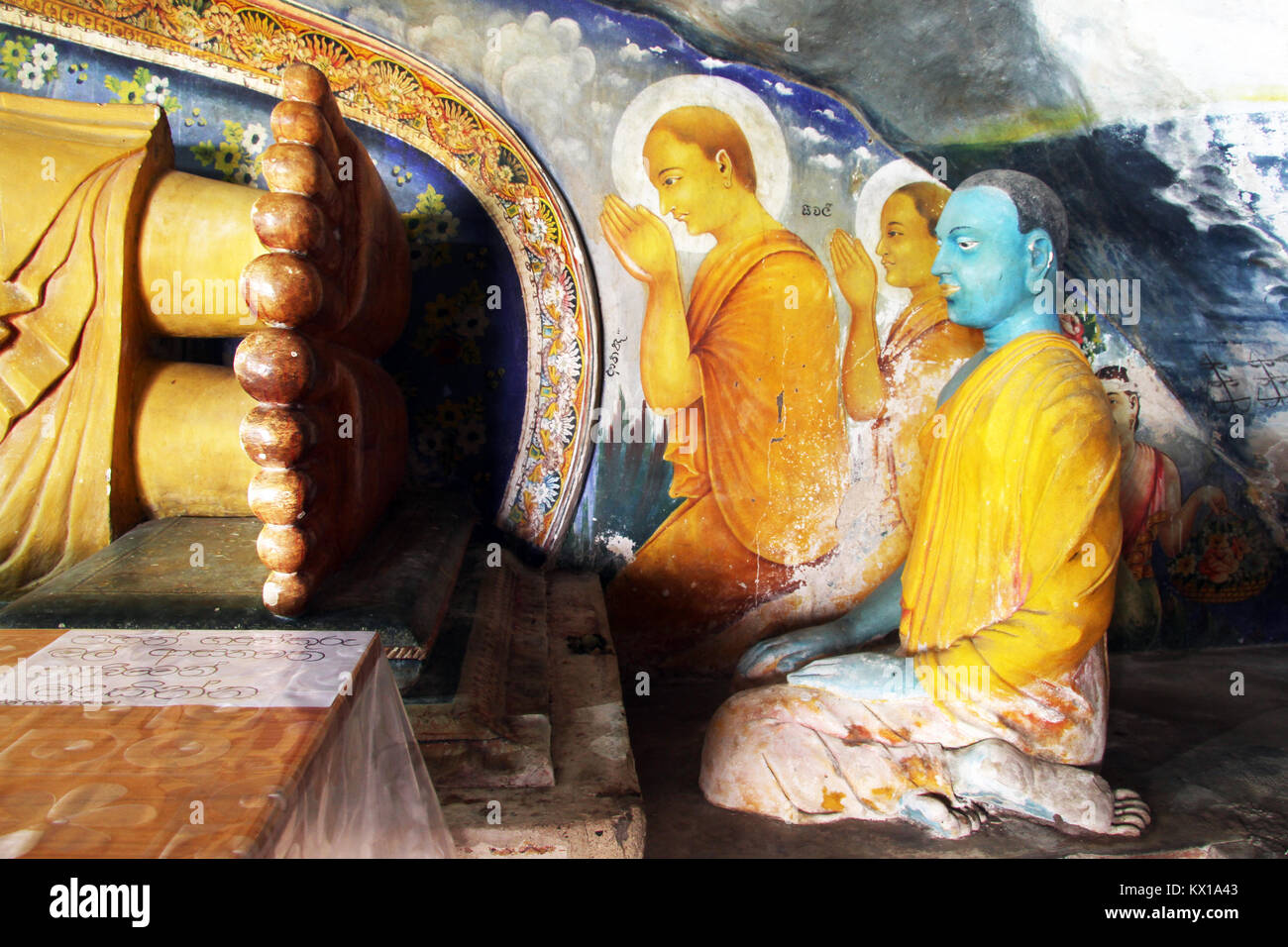 Monks seated near Buddha's feet Stock Photo - Alamy