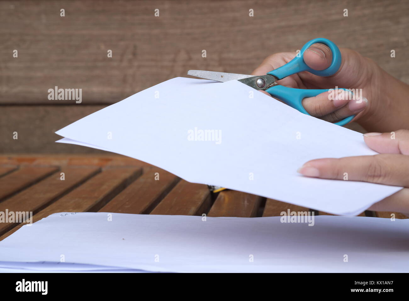 Hand cutting paper with scissors Stock Photo - Alamy