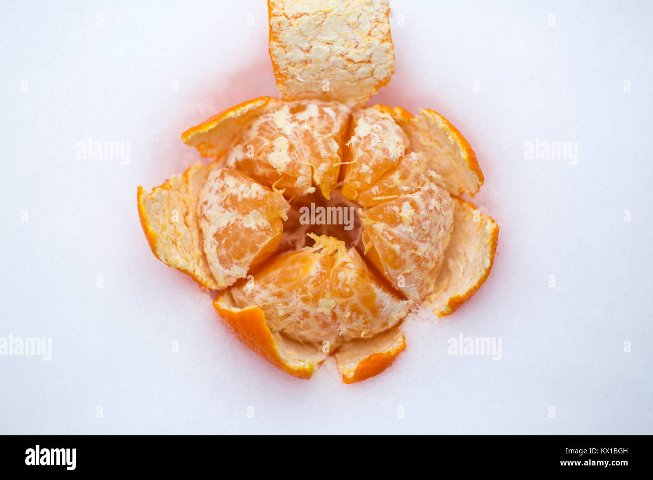 Peeled orange sitting open on snow Stock Photo - Alamy