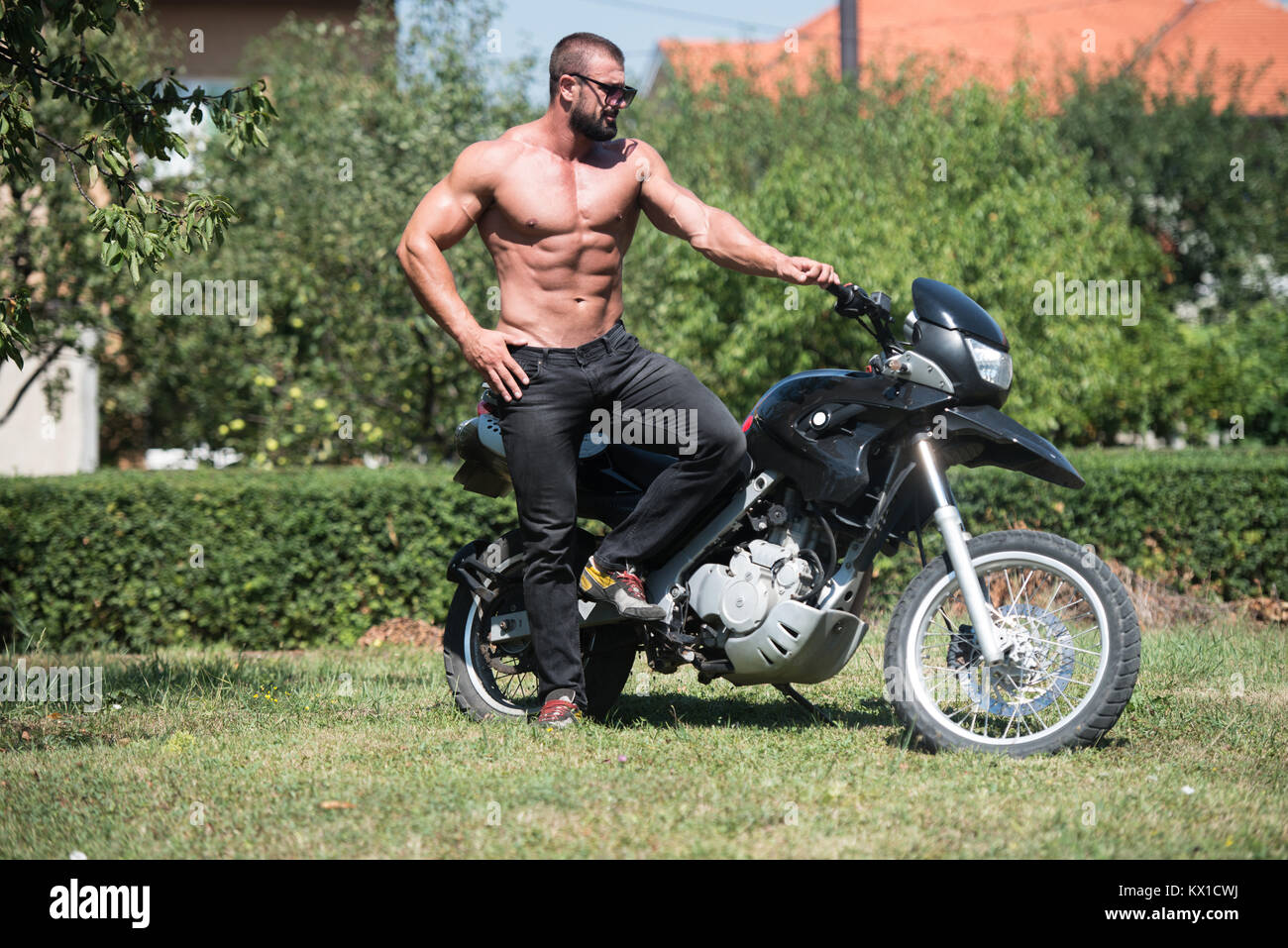 Biker Man Bodybuilder And The Bike Stock Photo - Alamy