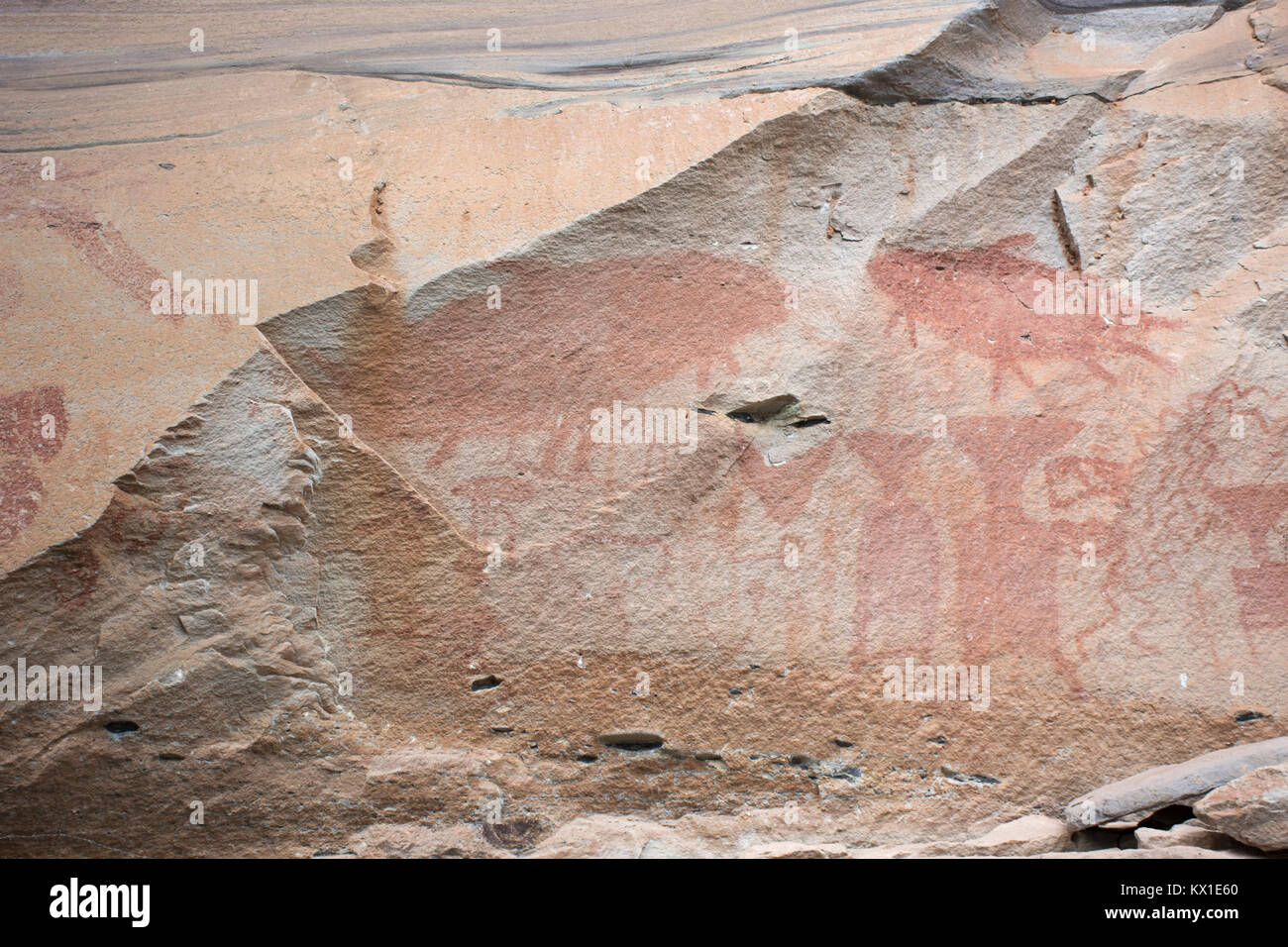Rock art includes both humanoid and animal figures on cliffs above the ...