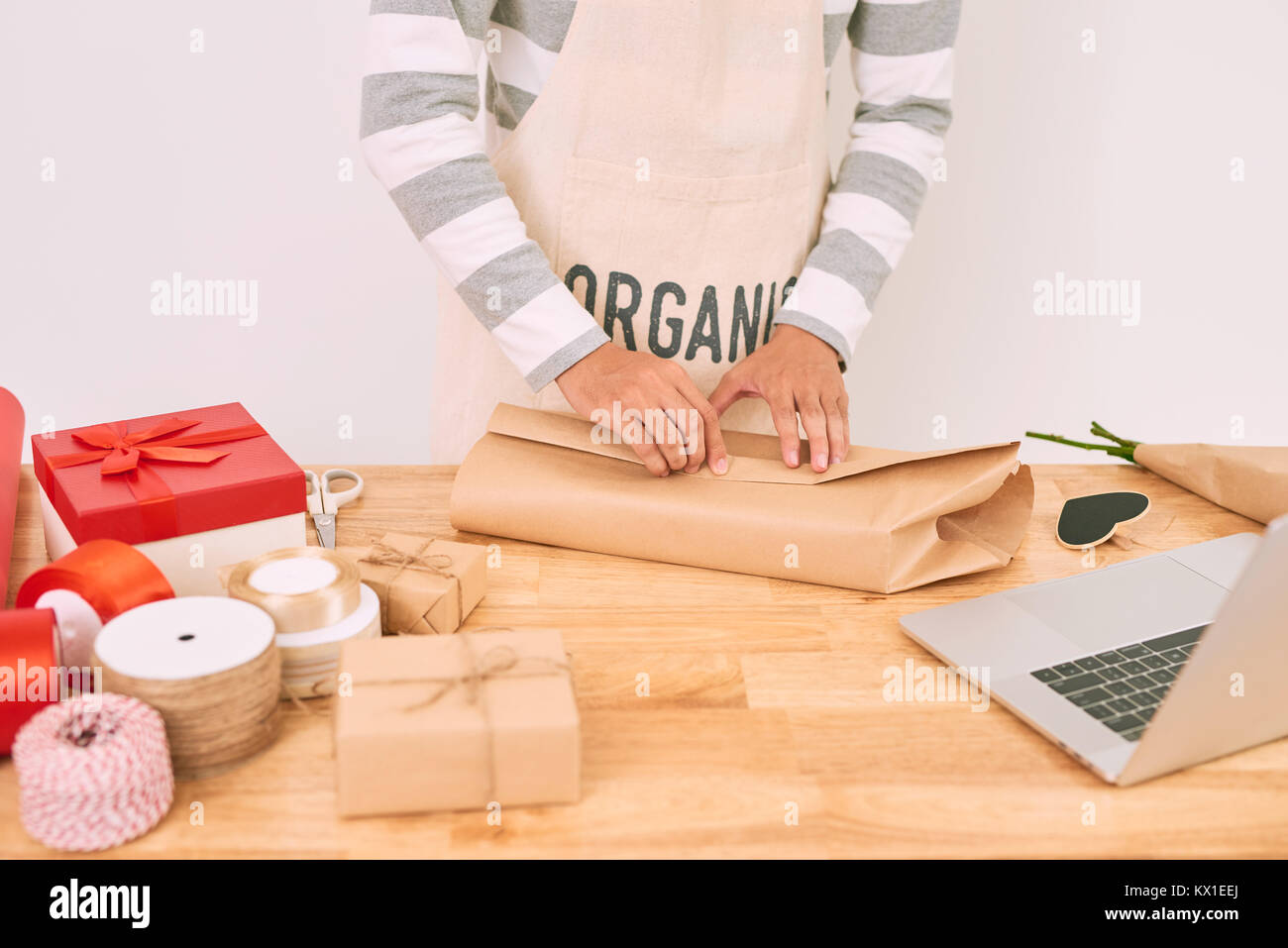 Asian man wrapping purchase while working in shop of gifts Stock Photo ...