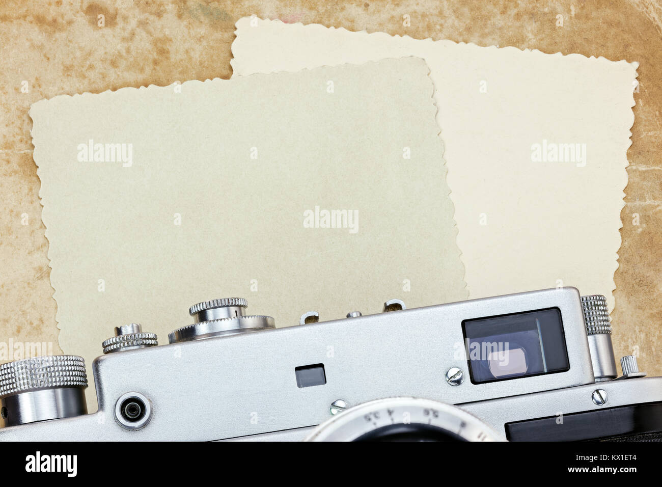 antique classic camera and aged photo cards on grunge paper background ...