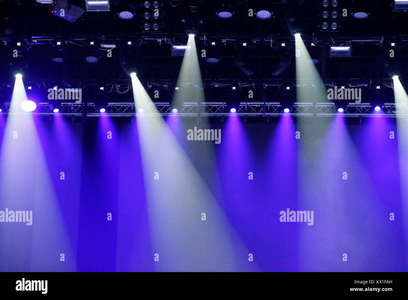Concert spotlights.Blue and white rays of powerful projectors on stage ...