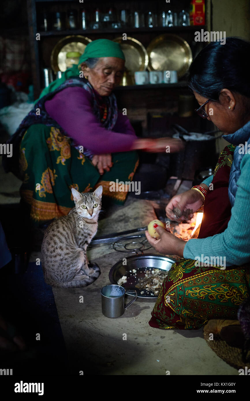Gurung women preparing food, and cat waiting, Chomrong, Annapurna ...