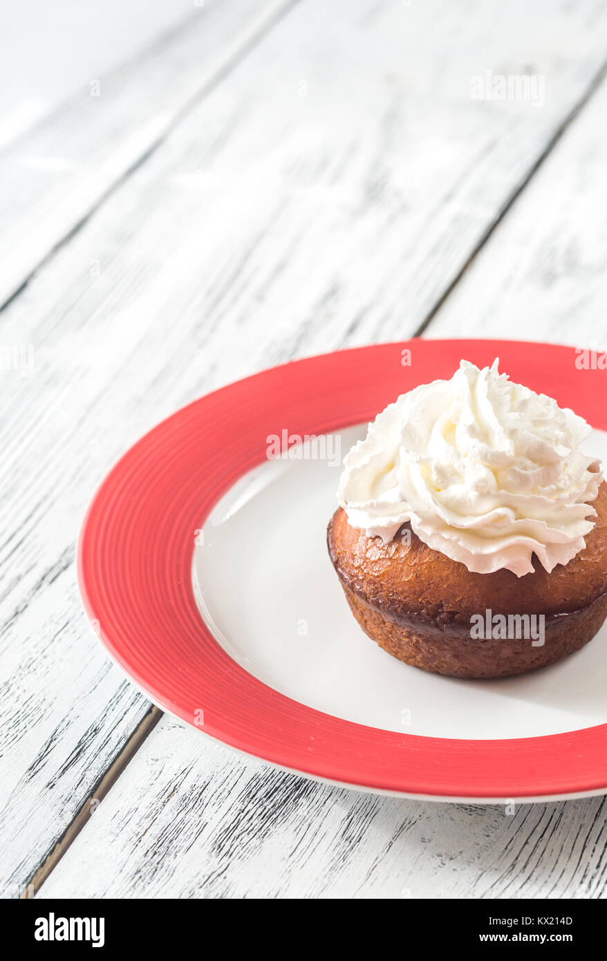 Rum baba decorated with whipped cream on the plate Stock Photo - Alamy