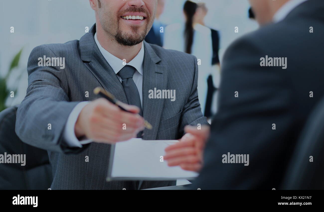 Businessman giving a pen his customer Stock Photo - Alamy