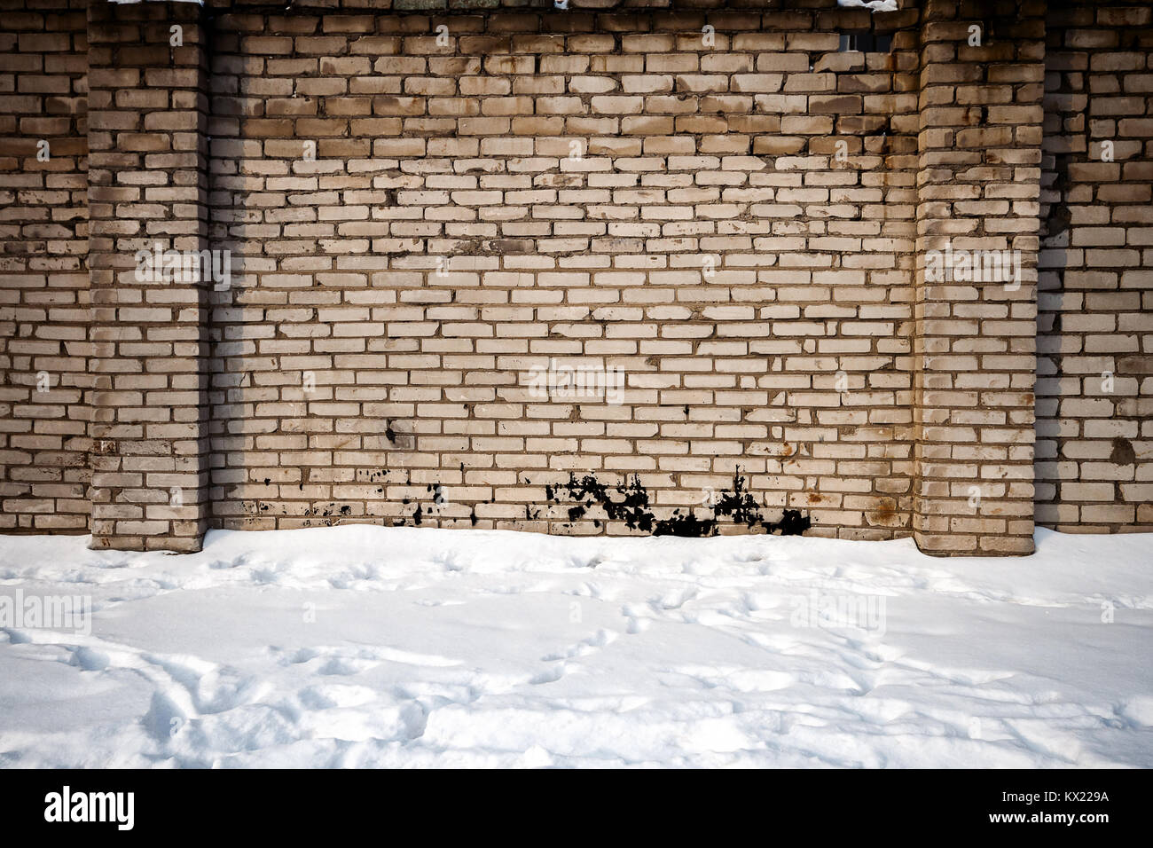 White brick wall and a ground covered with snow Stock Photo - Alamy