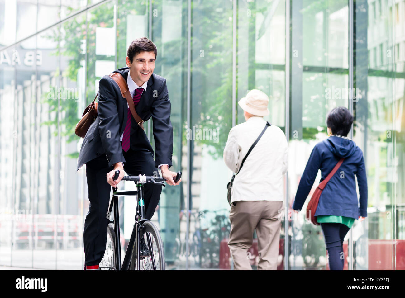 Cheerful young employee riding an utility bicycle in Berlin Stock Photo ...