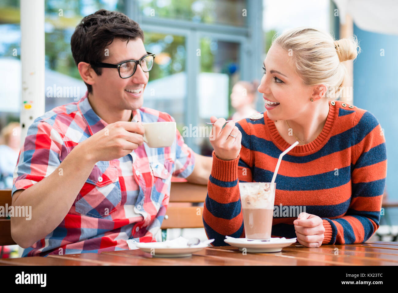 Couple having coffee in a street cafe Stock Photo - Alamy