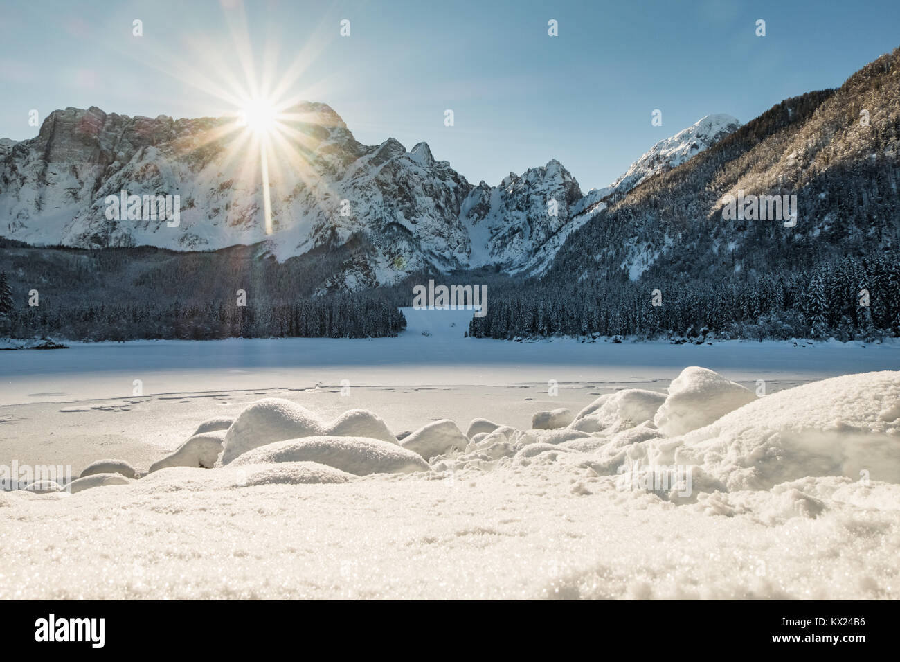 Mountain range Mangart seen from snow covert frozen lake Fusine with ...