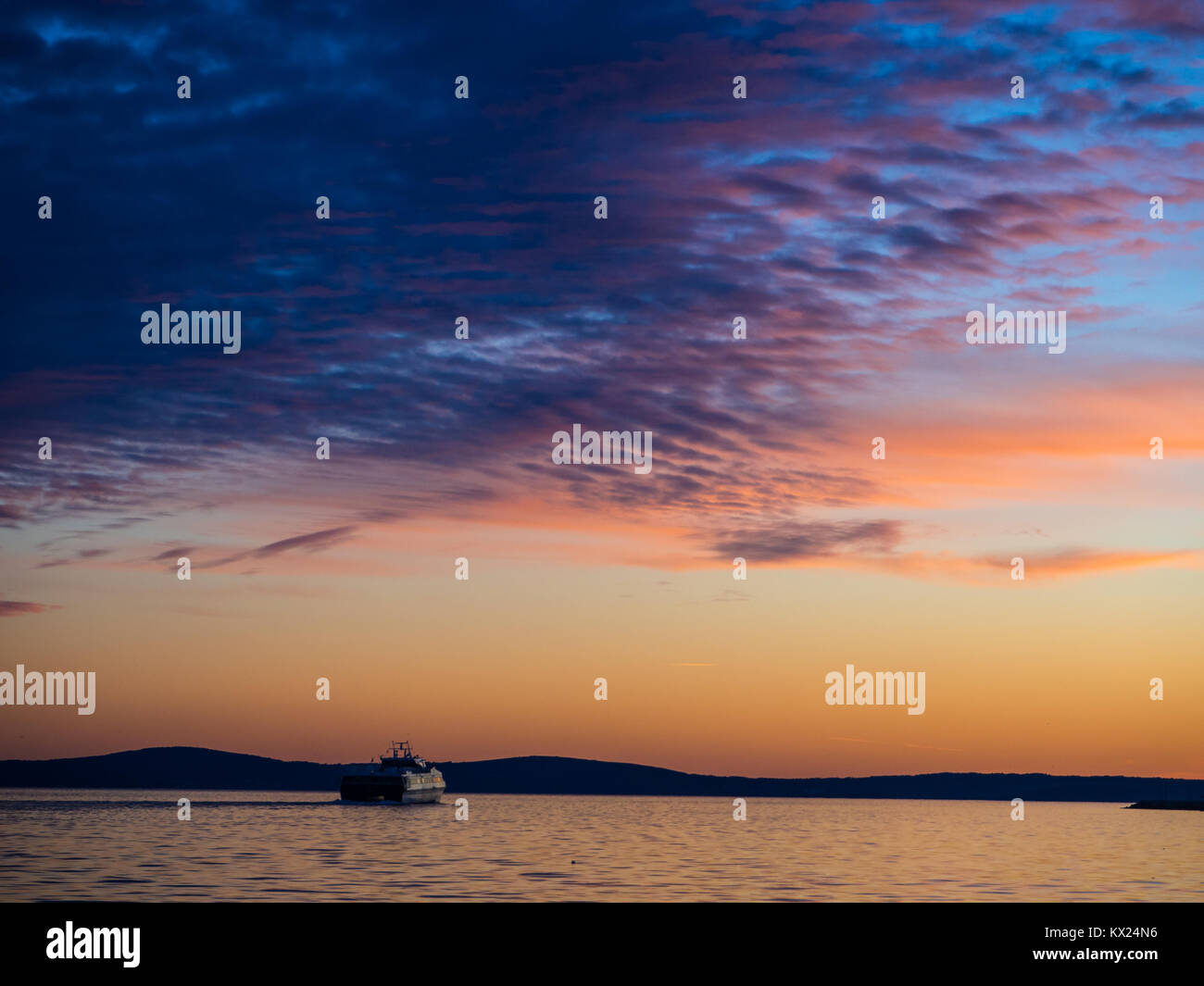 Ship sailing into the sunset Stock Photo - Alamy