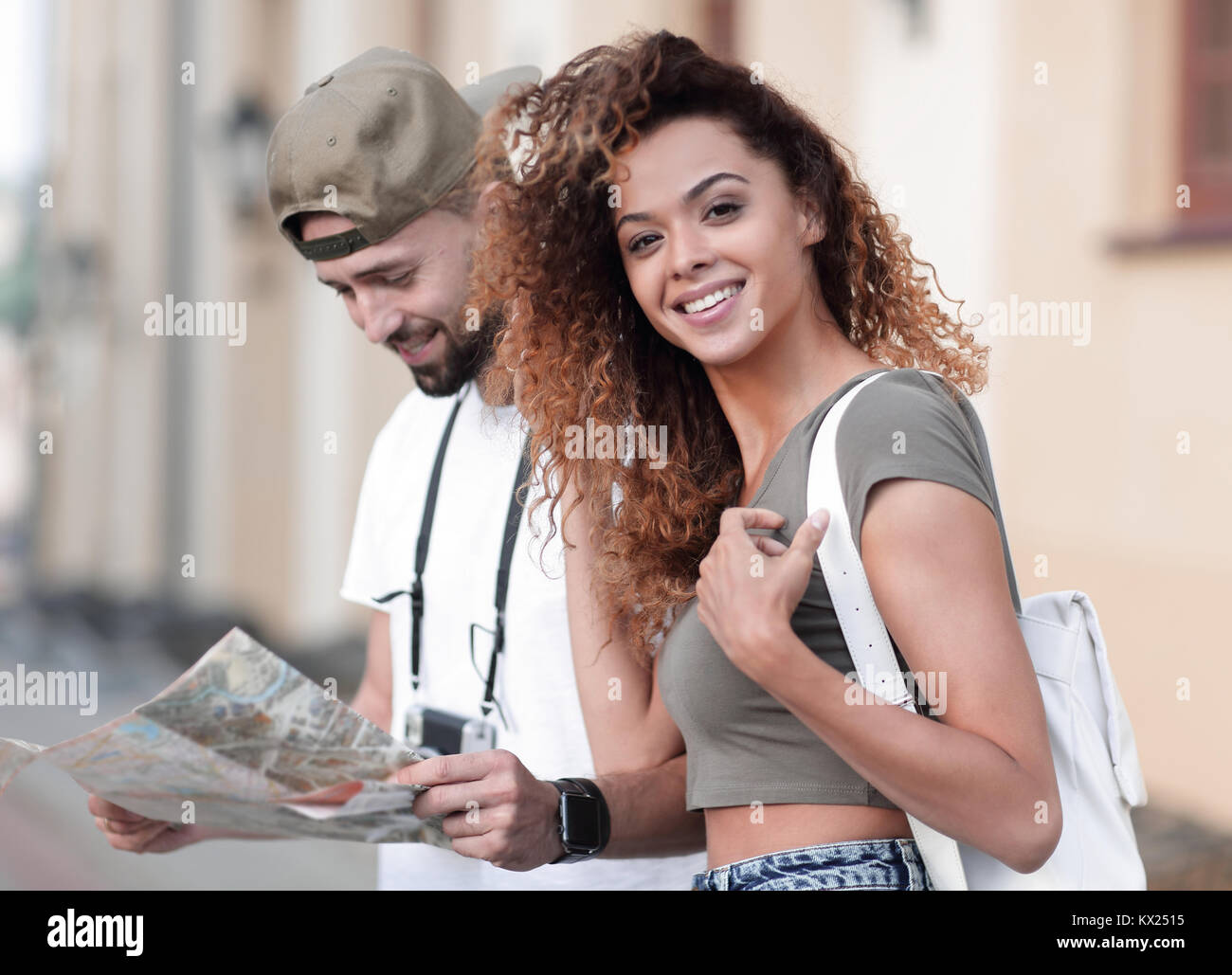 Happy tourist couple with map looking for a way and smiling Stock Photo ...