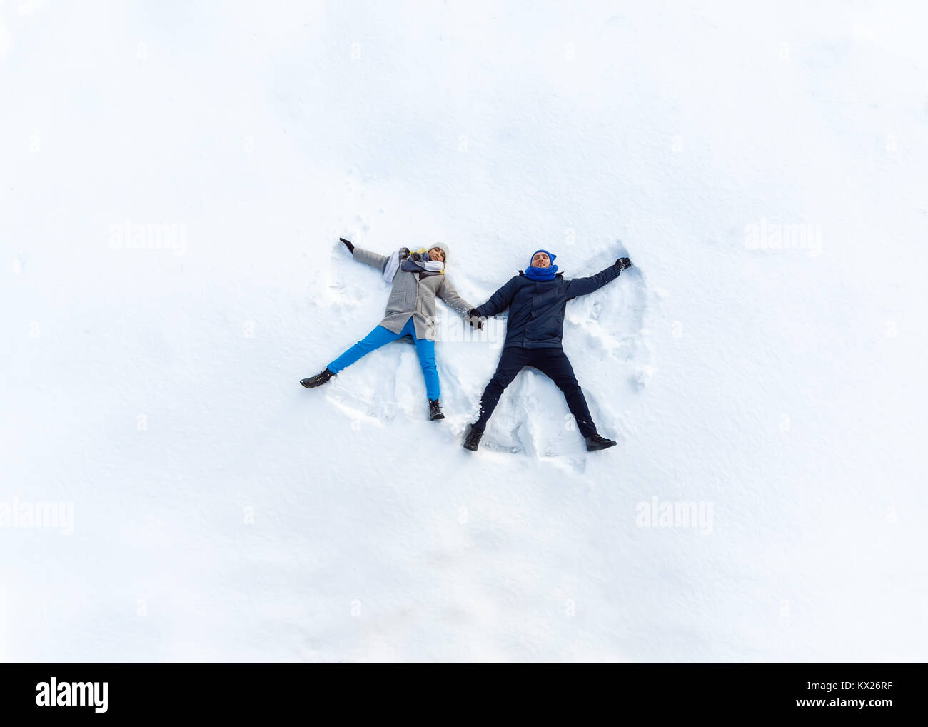 Happy Young Couple in Winter Park Lying On Snow. Making Snow Angel. top ...
