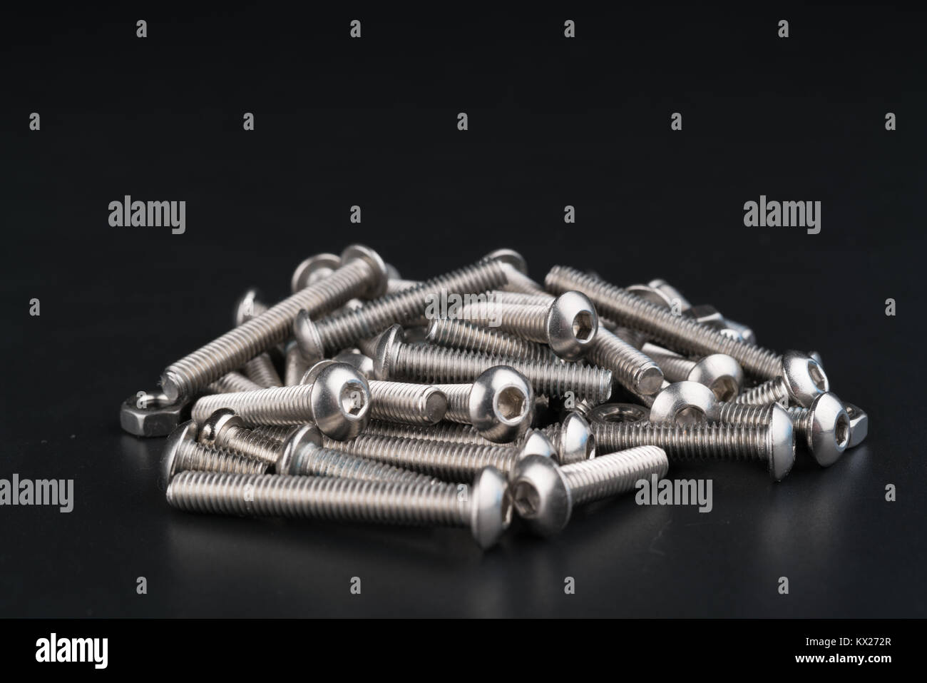 metal fasteners screws and nuts on black background. screw isolated on ...