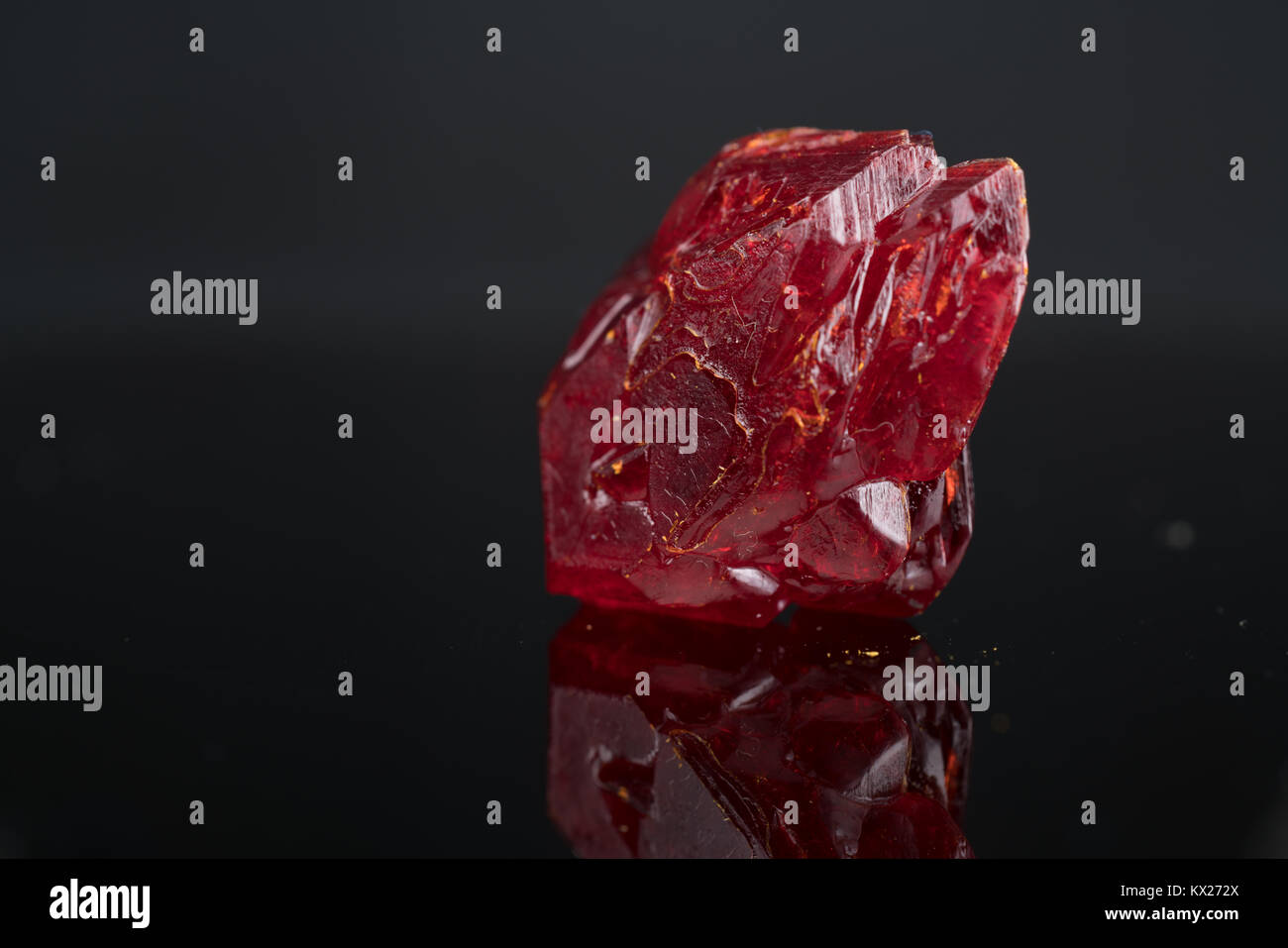 Red natural crystal mineral on a black background Stock Photo - Alamy