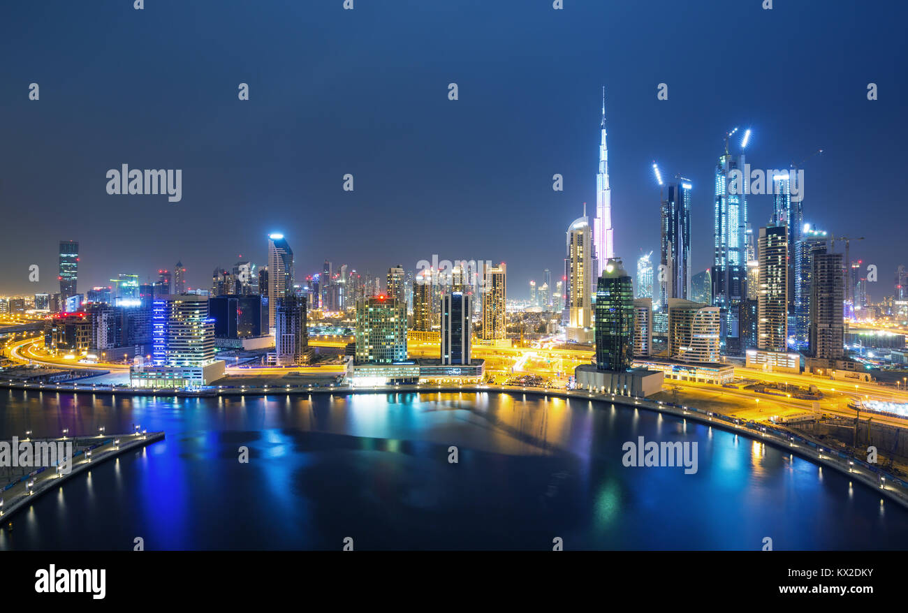 Dubai skyline after sunset with beautiful city center lights reflection ...