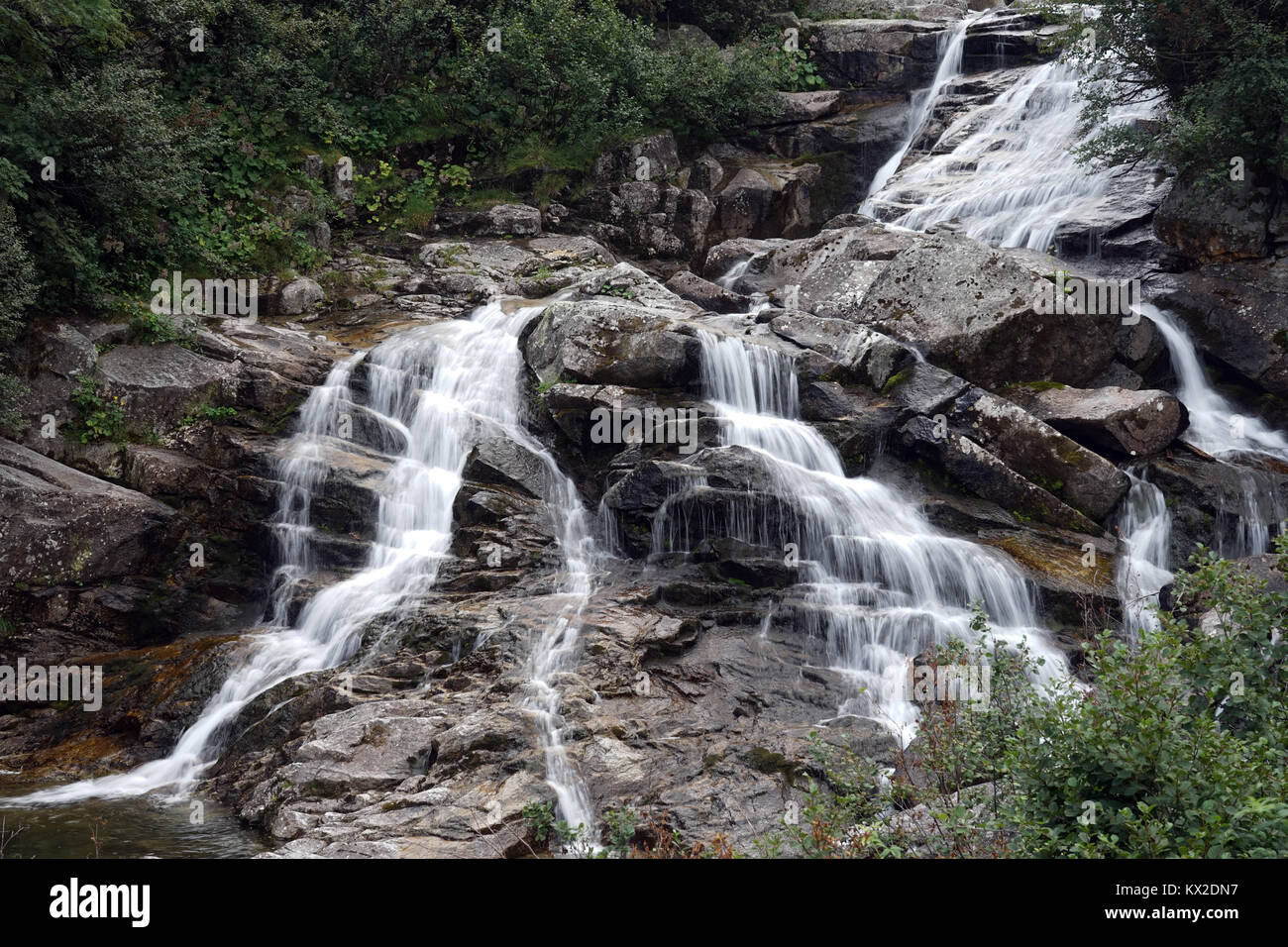 Narrow river with small waterfall near Gotthardpass in Switzerland ...