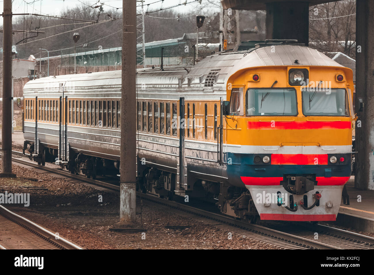 Old yellow passenger diesel train moving at the terminal Stock Photo ...
