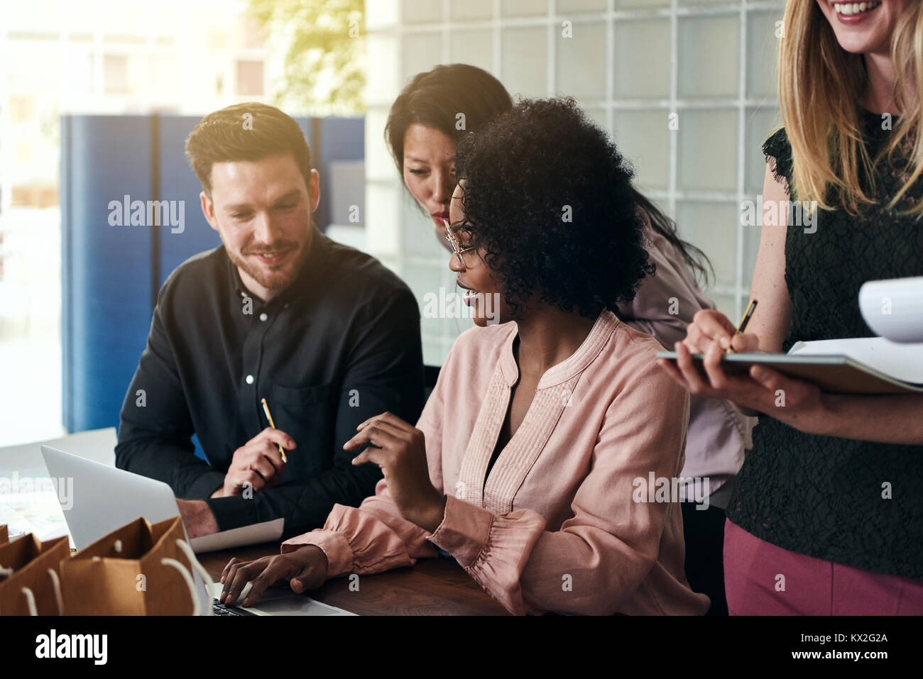 Group of diverse business colleagues smiling while working together on ...