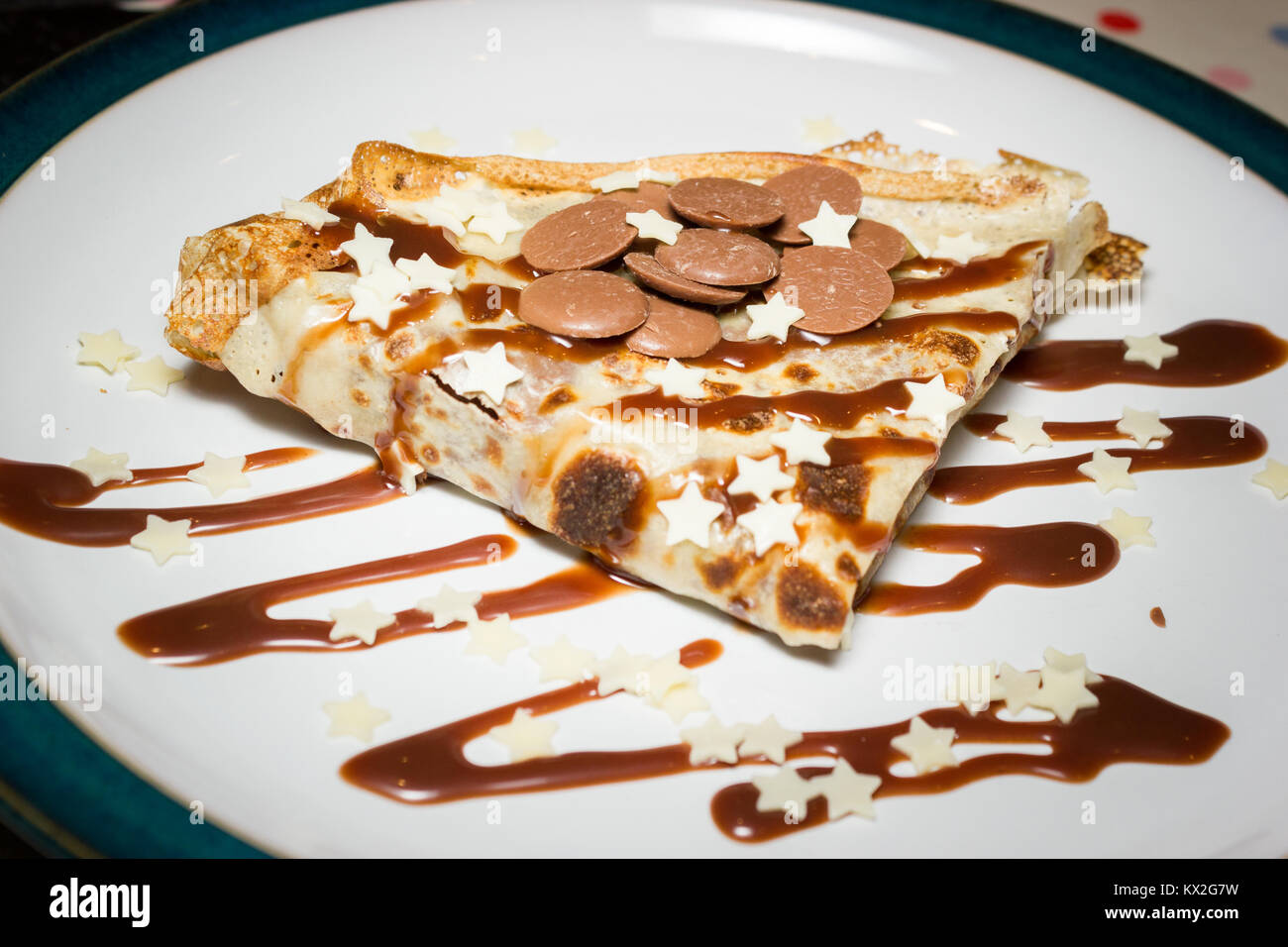 Pancake slice decorated with chocolate sauce, chocolate buttons and ...