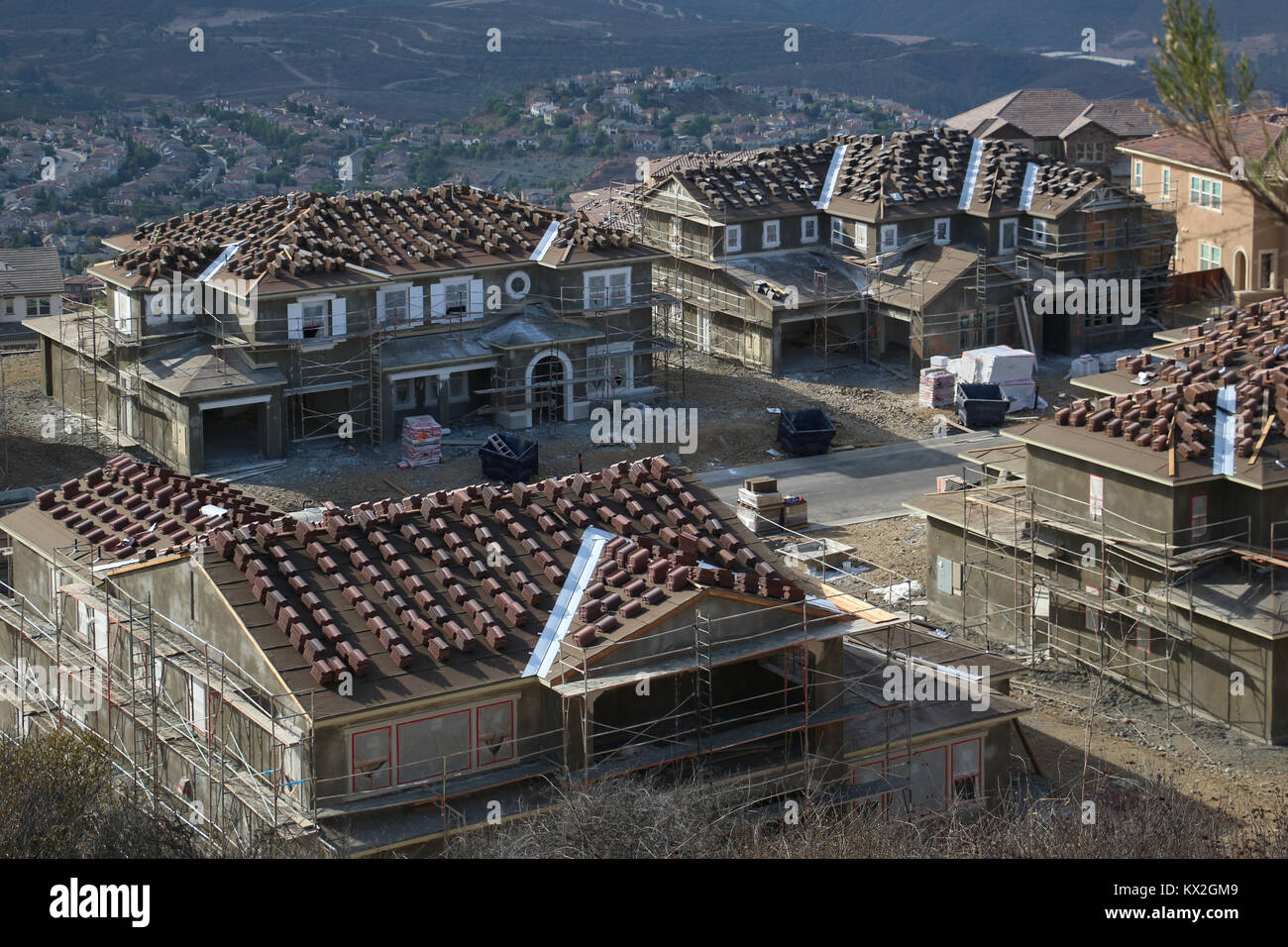 Four large upscale new homes under construction in California hillside development, all with ...