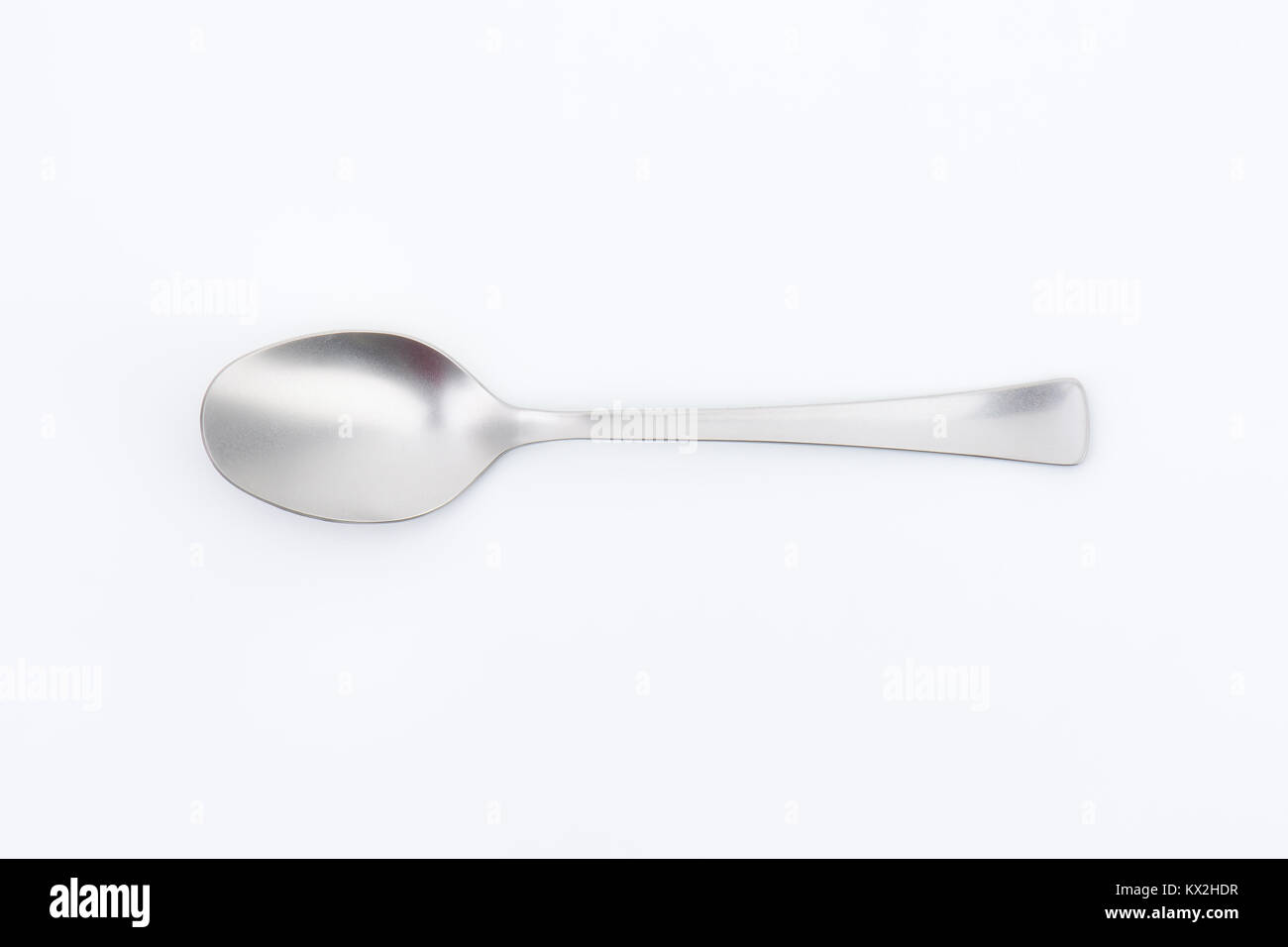 Small empty metal spoon on white background Stock Photo - Alamy