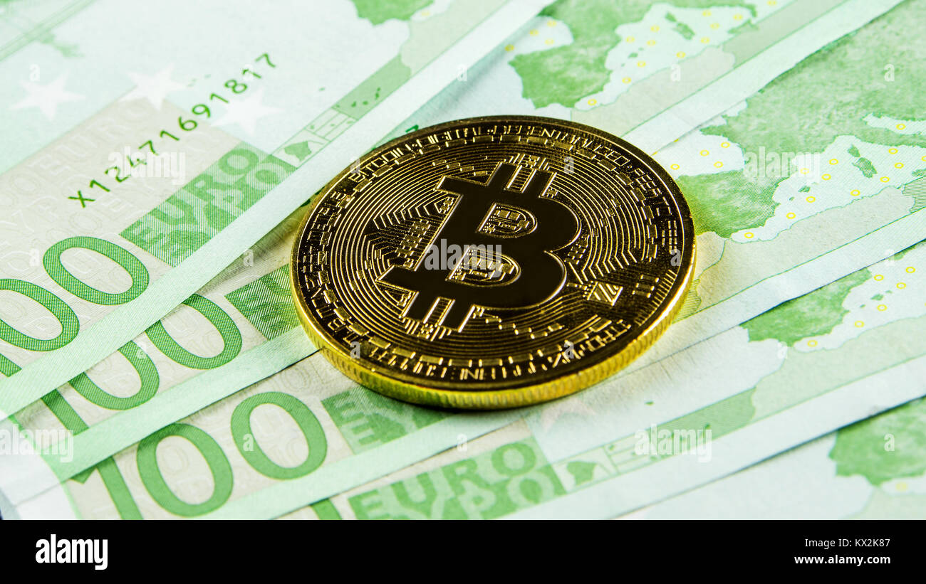 one hundred euro banknotes laying as background with one golden bitcoin ...