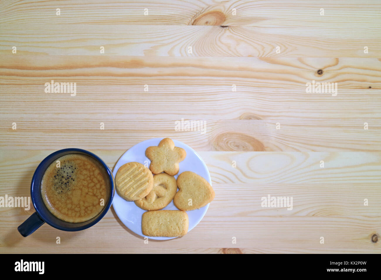Top view of a cup of coffee with a plate of butter cookies on wooden ...
