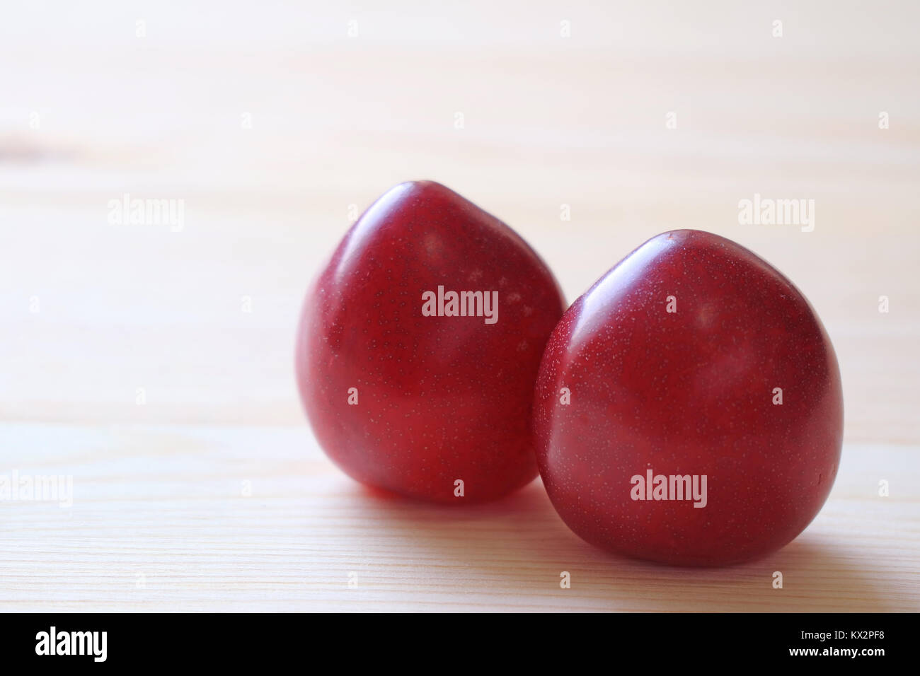 Closed up of Two Heart Shaped Ripe Gulf Ruby Plum Fruits on Wooden ...