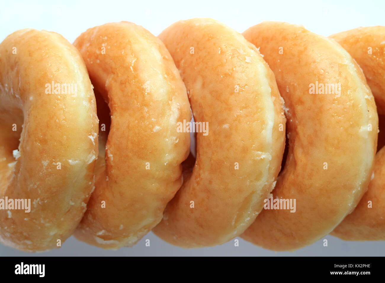Close-up of lined up sugar-glazed doughnuts texture, top view for ...