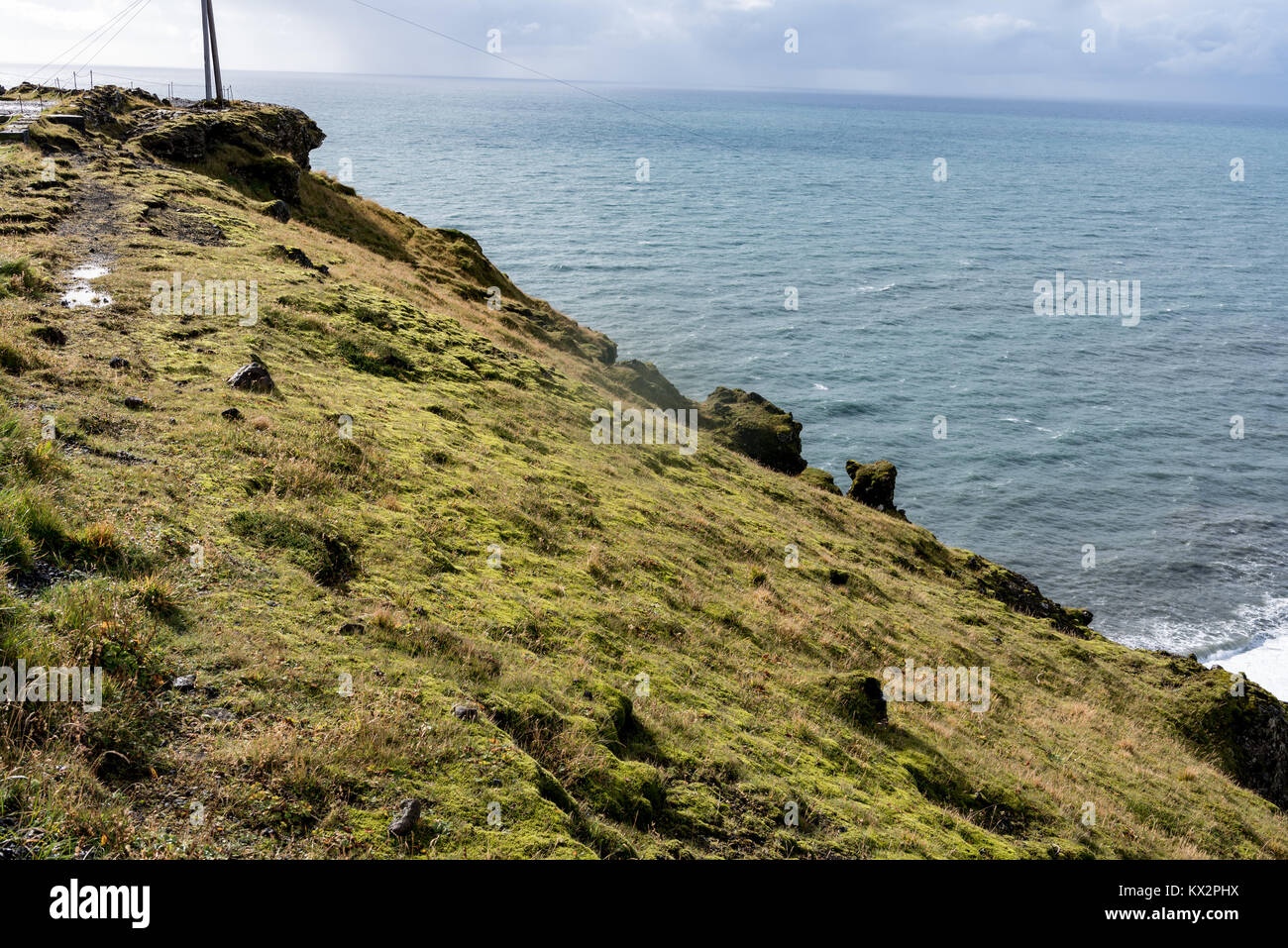 Cliff side with blue sea behind Stock Photo - Alamy